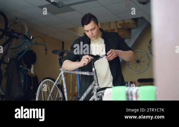 Skilled mechanic is fixing handle-bar of modern bicycle using ...