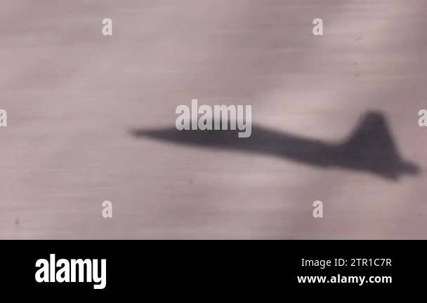 Shadow of a low flying military aircraft sweeps across the terrain ...