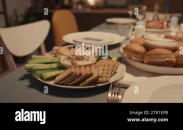 Close-up shot of platters with traditional Jewish foods on candlelit ...