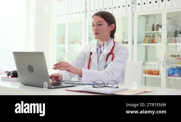 Female doctor typing on laptop keyboard and closing and sitting at ...