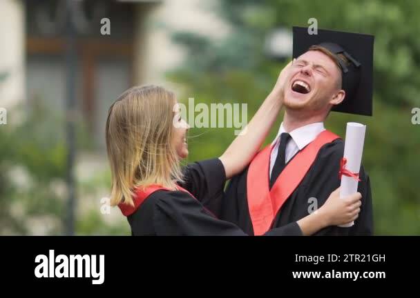 Young funny male and female graduates laughing, celebrating graduation ...