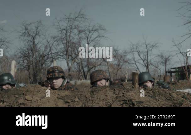 Group of soldiers wearing combat helmets standing in frontline trench ...