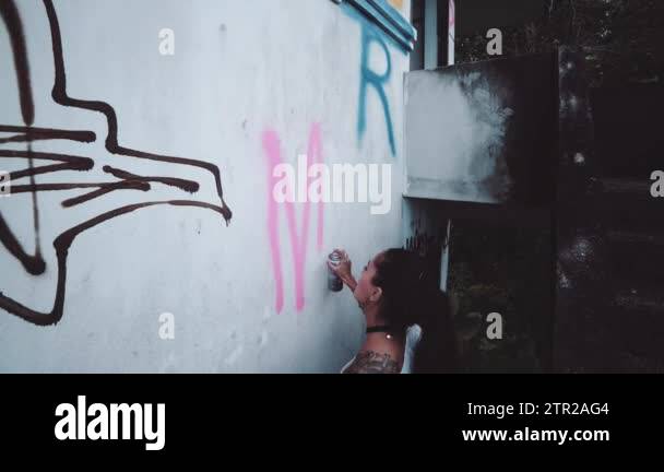Graffiti artist girl/Graffiti artist girl painting on the wall of ...
