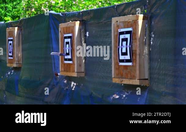 Throwing knives at the target from an open-air distance, a competition for throwing knives ...