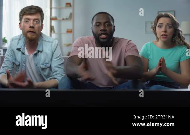 Bachelor and neighbor couple watching football championship on tv ...