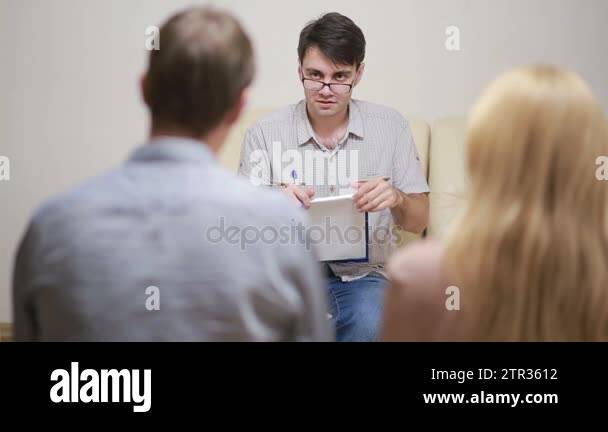 male psychologist helping worried young couple. family therapy. angry ...