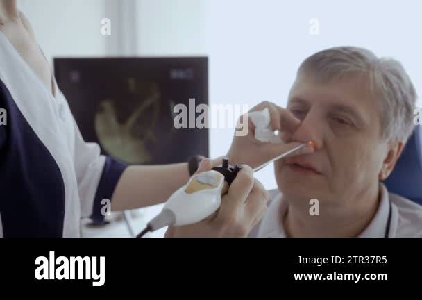 Doctor examine patient nose with ENT telescope and look at the screen ...