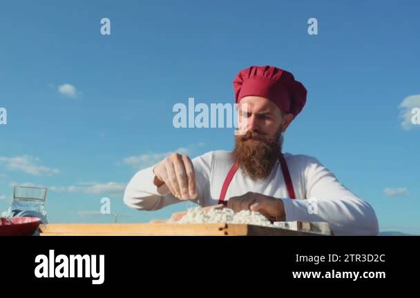 Bearded chef cooking on fresh air. Baker baking bread . Baker kneading ...