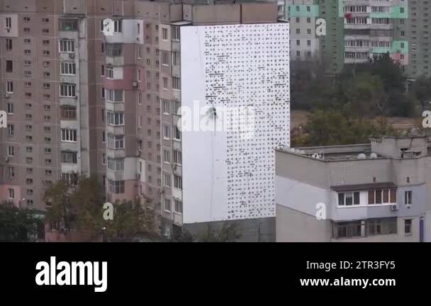High-altitude work. The man works on high-rise works cladding ...