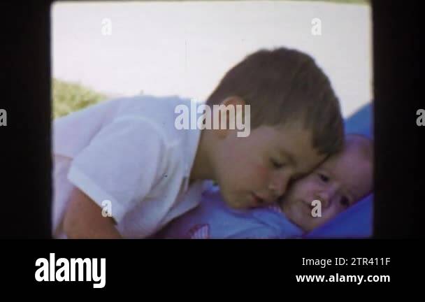 Brother cuddling nuzzle against baby boy Stock Video Footage - Alamy