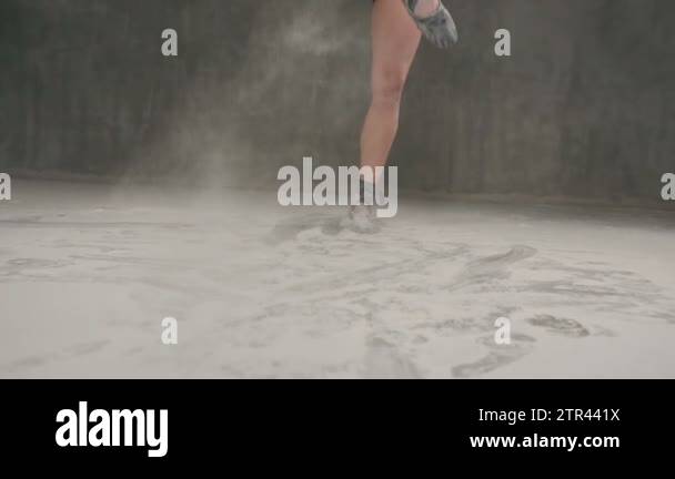 Ballerina girl dancing ballet in ballet shoes in white powder or dust ...
