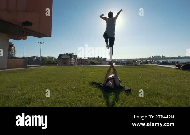 Young sporty couple practicing acrobatics performing front plank bird ...