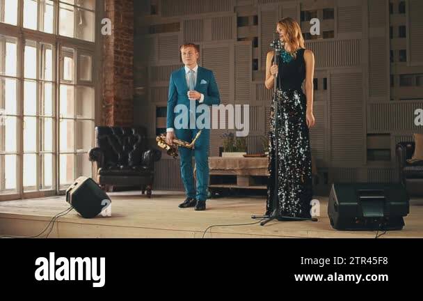 Jazz vocalist in glare dress, saxophonist in blue suit prepare perform ...