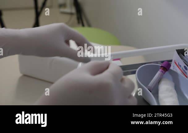 Nurse puts on bar code sticker on vacutainer after blood draw for ...