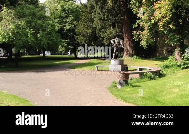 Mman rides bicycle in the Aldenhofpark in front of the statue of ...