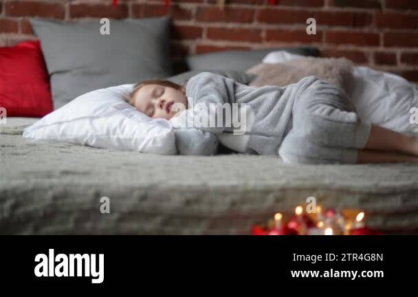 Cute girl sleeping on the bed with christmas presents standing near her ...