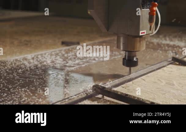 CNC machine is carving plastic detail from billet in factory ...