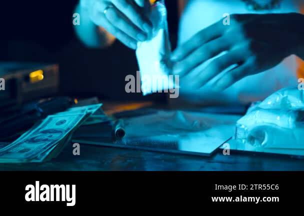 Drug dealer takes a package with a drug and cuts it with a knife to ...