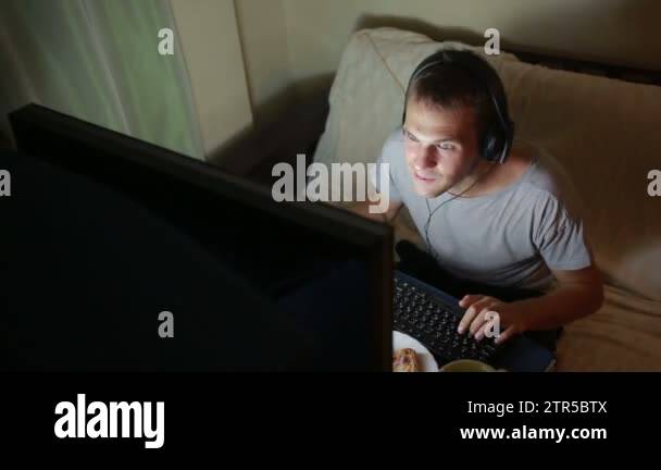 man playing video games on your computer. late at night on the computer ...