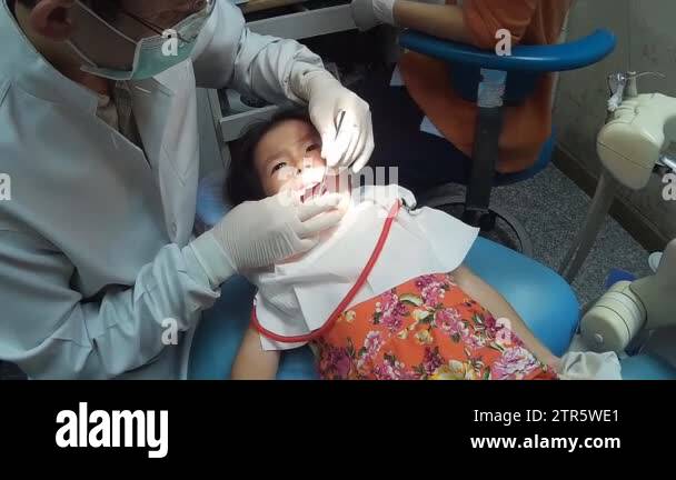 Little girl opening his mouth wide during inspection of oral cavity ...