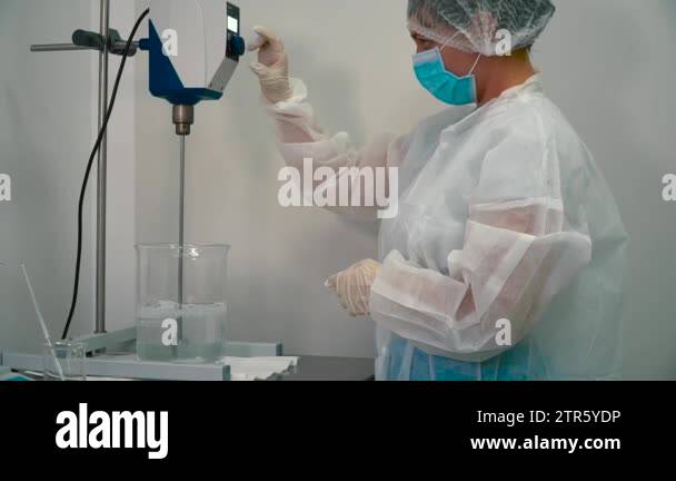 Chemist adjust mixing equipment in laboratory. The woman moving the ...