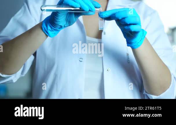 Scientist woman pouring liquid into medical spectro in laboratory or ...