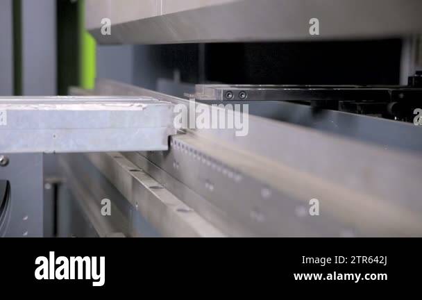 Worker hands bend metal sheet on a modern bending industrial machine at ...
