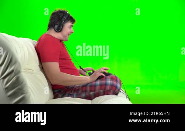 Gamer playing computer games sitting on the sofa. Green screen Stock ...