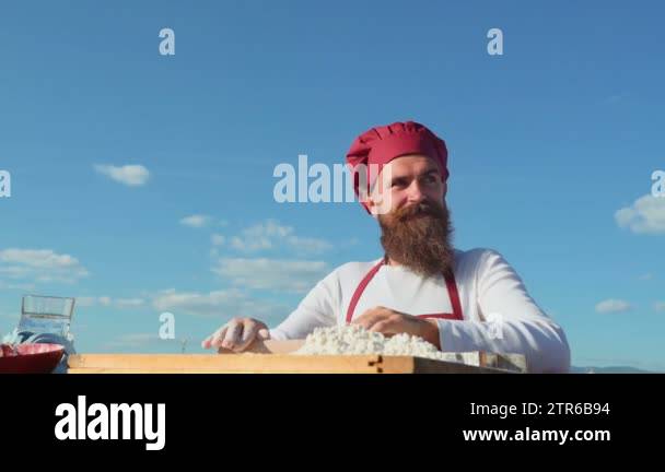 Bearded chef cooking on fresh air. Baker baking bread . Baker kneading ...