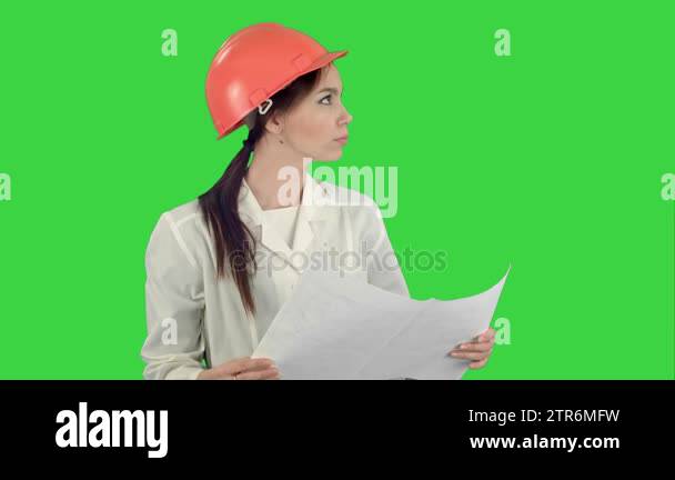 Young female architect holding blueprints and checking construction on ...