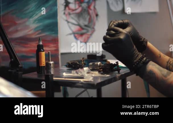 tattoo artist collects the tattoo machine. girl tattoo master prepares ...