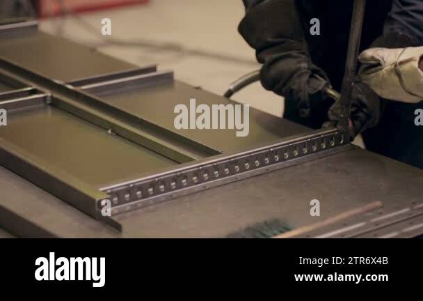 Two welders working, welding metal pieces together at a industrial ...