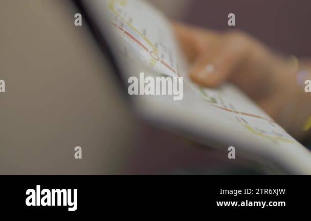 Close up view of hand with paper map of subway station and then ...
