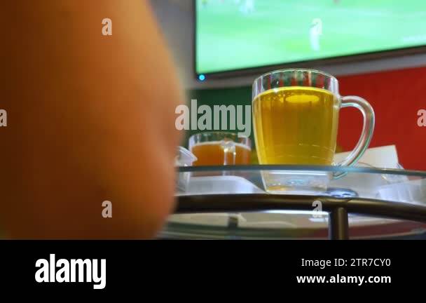 Watching football game on television at local pub. Food, beer. a mug ...