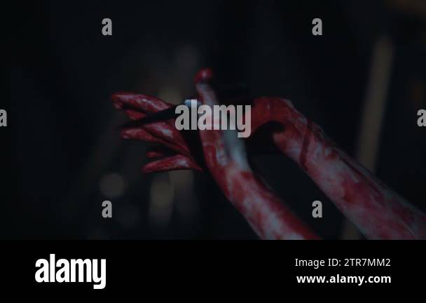Scary scene, shaky bloody hands of murderer holding knife and dropping ...