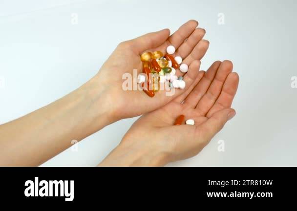 Multicolored vitamins and tablets in the hands of the girl. Pharmacy ...
