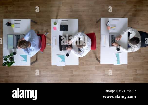 Three young businessman are working on laptops, leaving workplace ...