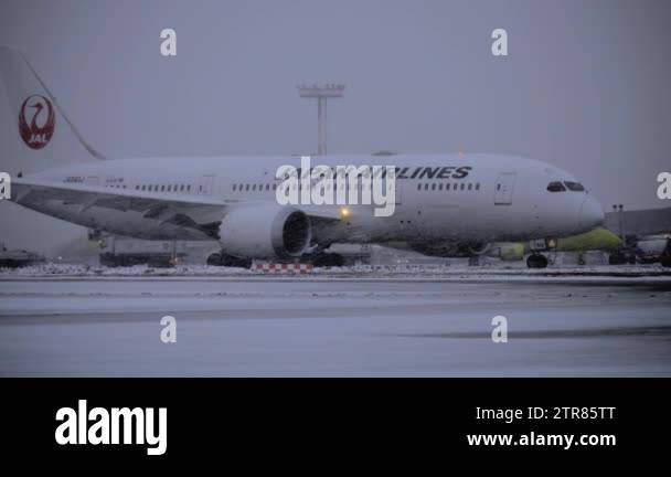 Boeing 787-8 Dreamliner of Japan Airlines under snowfall at the airport ...