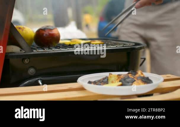 Burned potato chips and cooked apples closeup during family BBQ grill ...