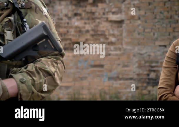 Young beautiful muslim woman in hijab looking at soldier with weapon ...