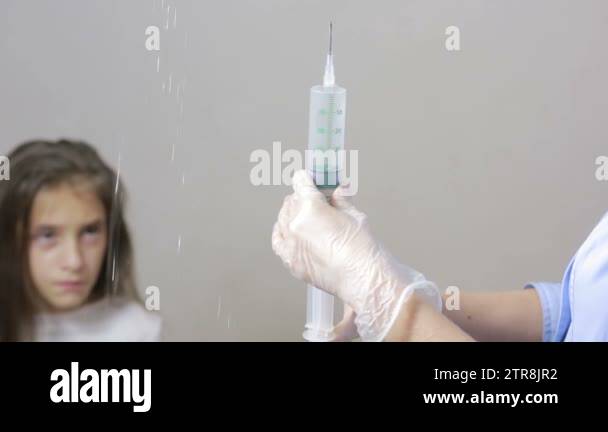 little girl is afraid of the doctor with a syringe. baby cries afraid ...