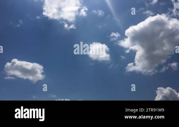 White clouds disappear in the hot sun on blue sky. Time-lapse motion ...
