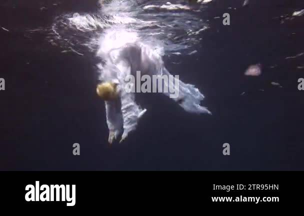 Underwater model free diver in costume angel swims in clean water in ...