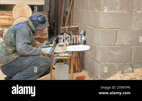 Work conducts prevention chainsaw. Man disassemble and clean the tool ...