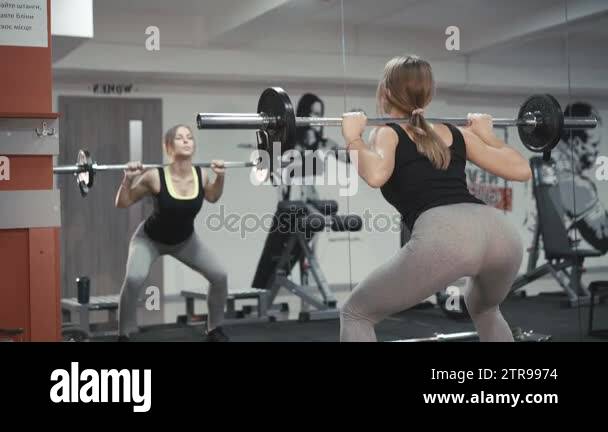 Back Look Of The Girl Doing Squats With Barbell In The Gym In 4k Stock