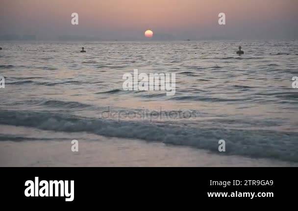 The sun sets behind the horizon. Waves Sea. Beach in the UAE Stock ...