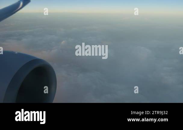 Aerial shot of a veil of white and fluffy clouds from a plane`s window ...