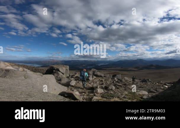 Trekking in Batea Mahuida volcano. Lady carrying baby walking up the ...