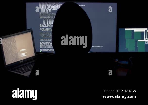 Hacker in hood cracking code using computers in dark room Stock Video ...