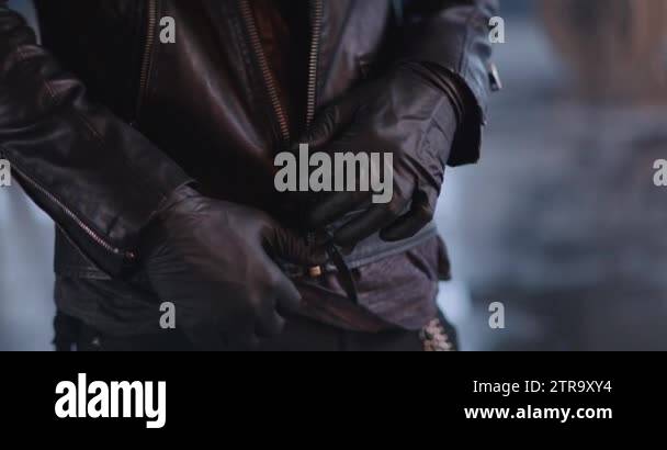 Man zipping a leather jacket in industrial background (4k, slow motion ...